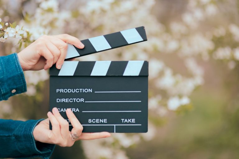 Hands Holding Film Slate Cinema Clapper on Spring Blooming Background ...